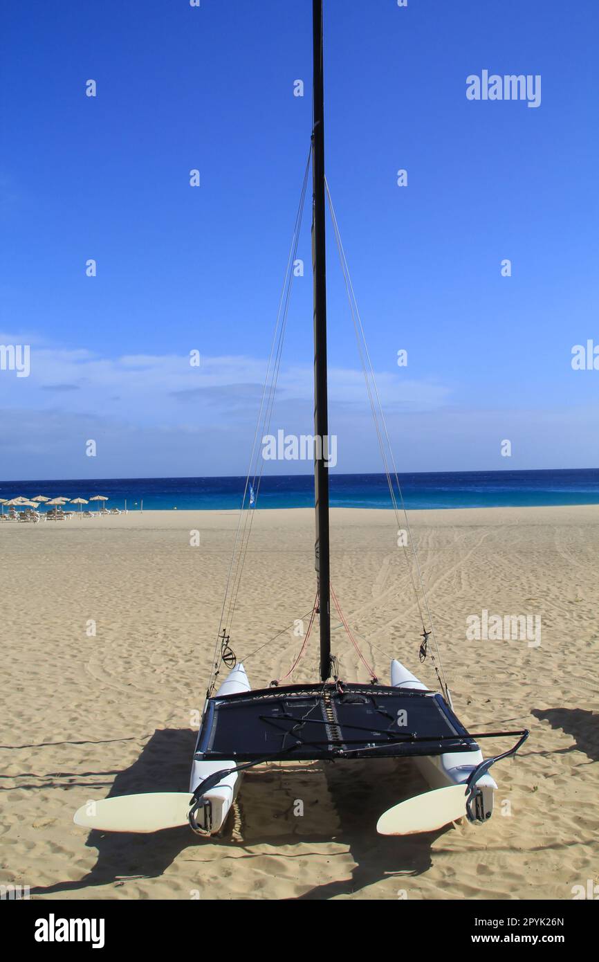 A sailing catamaran lies on the beach far from the water Stock Photo ...