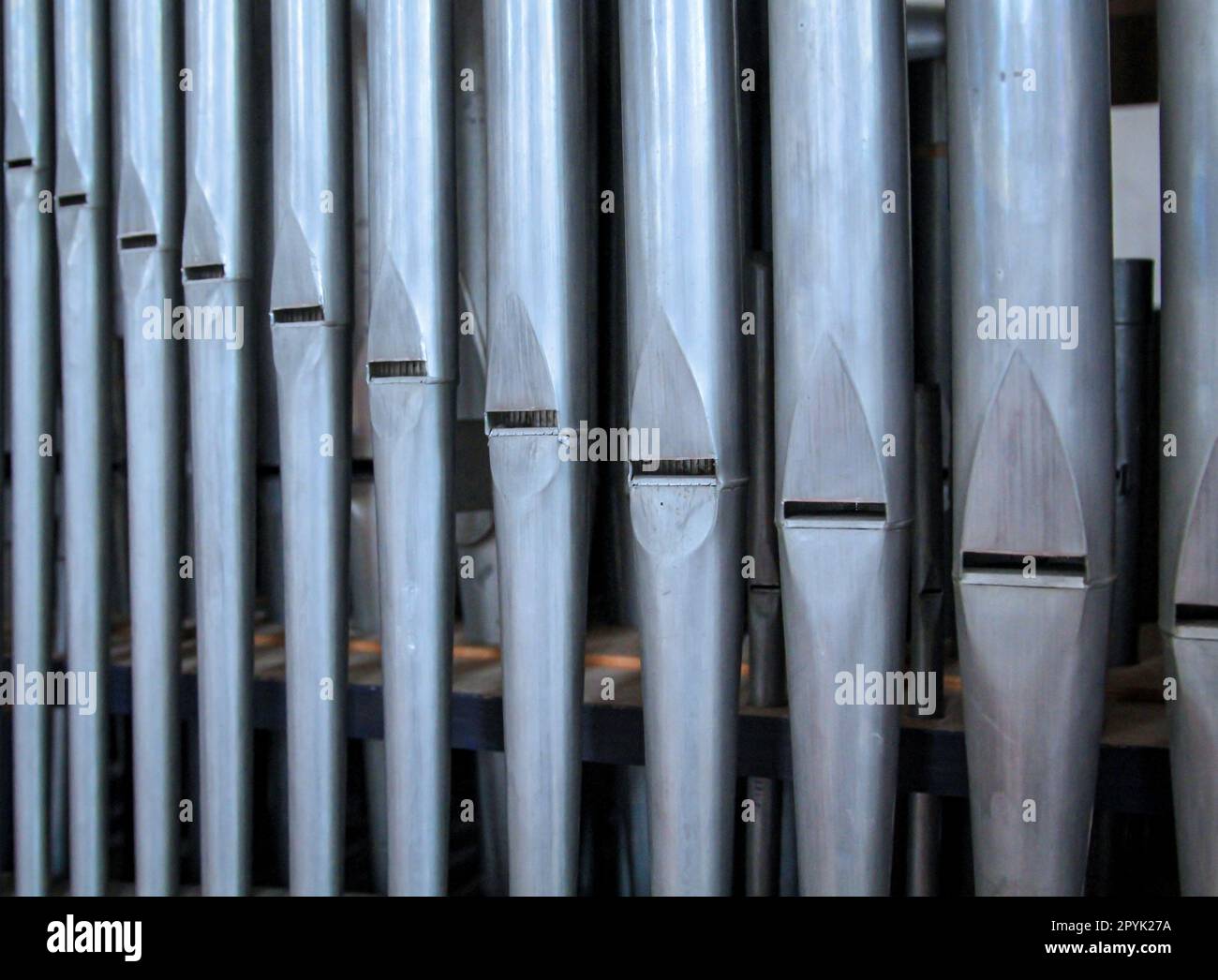Many organ pipes stand side by side in an organ over a bellows Stock ...