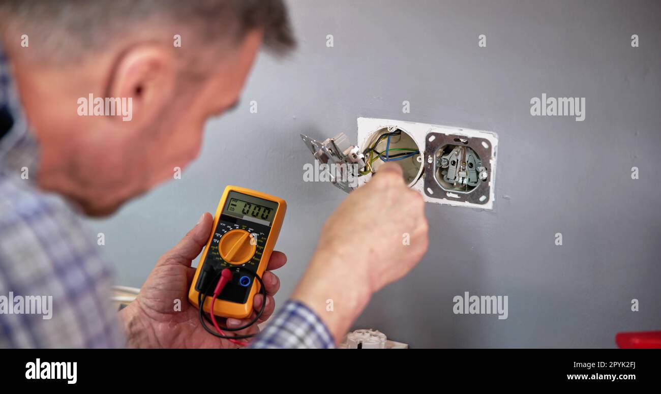 Male Electrician Checking Voltage Of Socket With Multimeter Stock Photo ...