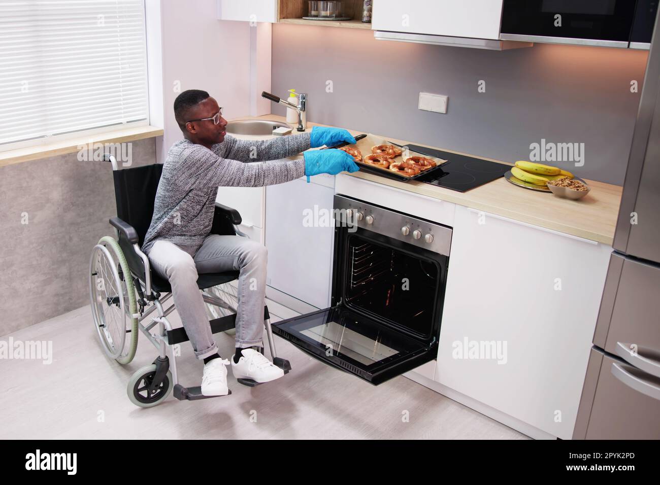 Disabled Man Using Microwave Oven For Baking Stock Photo - Alamy
