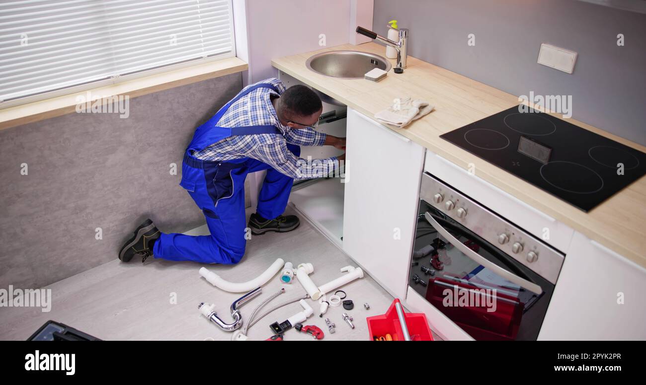 Plumber Cleaning Kitchen Drain And Pipe Stock Photo - Alamy