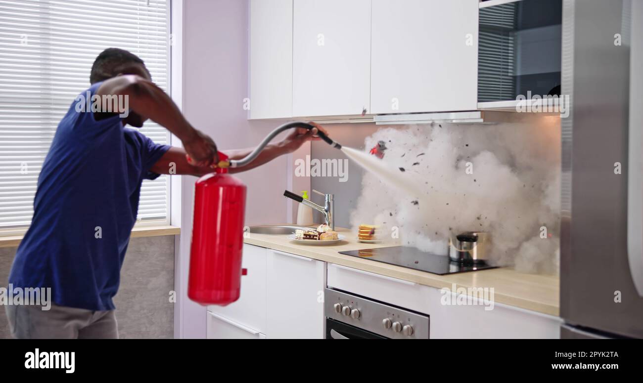Man Using Fire Extinguisher To Stop Fire Stock Photo - Alamy