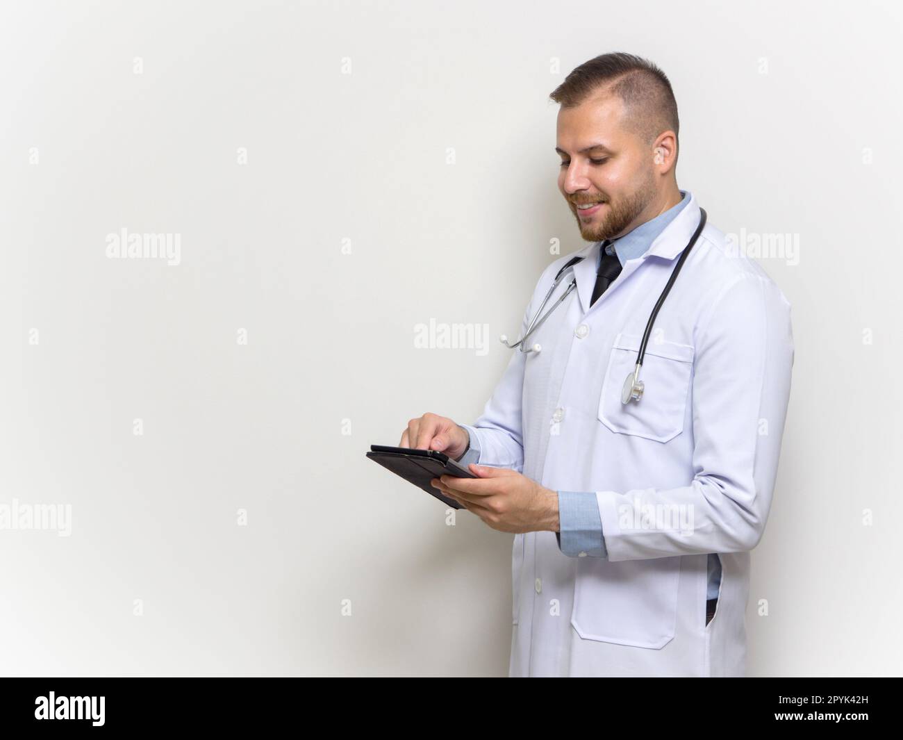Young caucasian doctor with short hair, mustache and beard. Dressed in ...