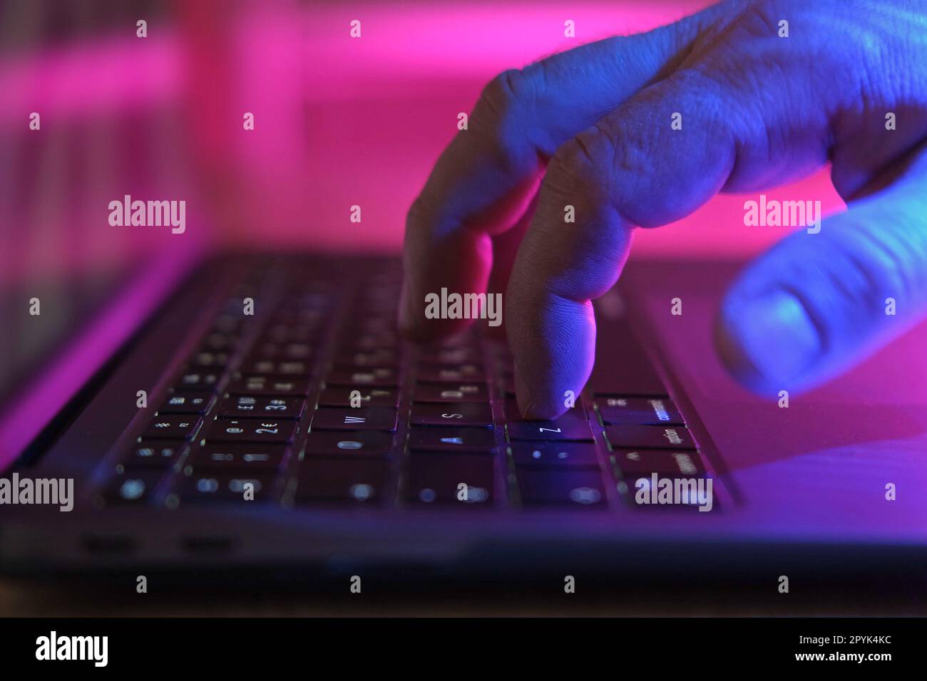 Person typing at laptop computer at night. Male uses keyboard, shakes ...