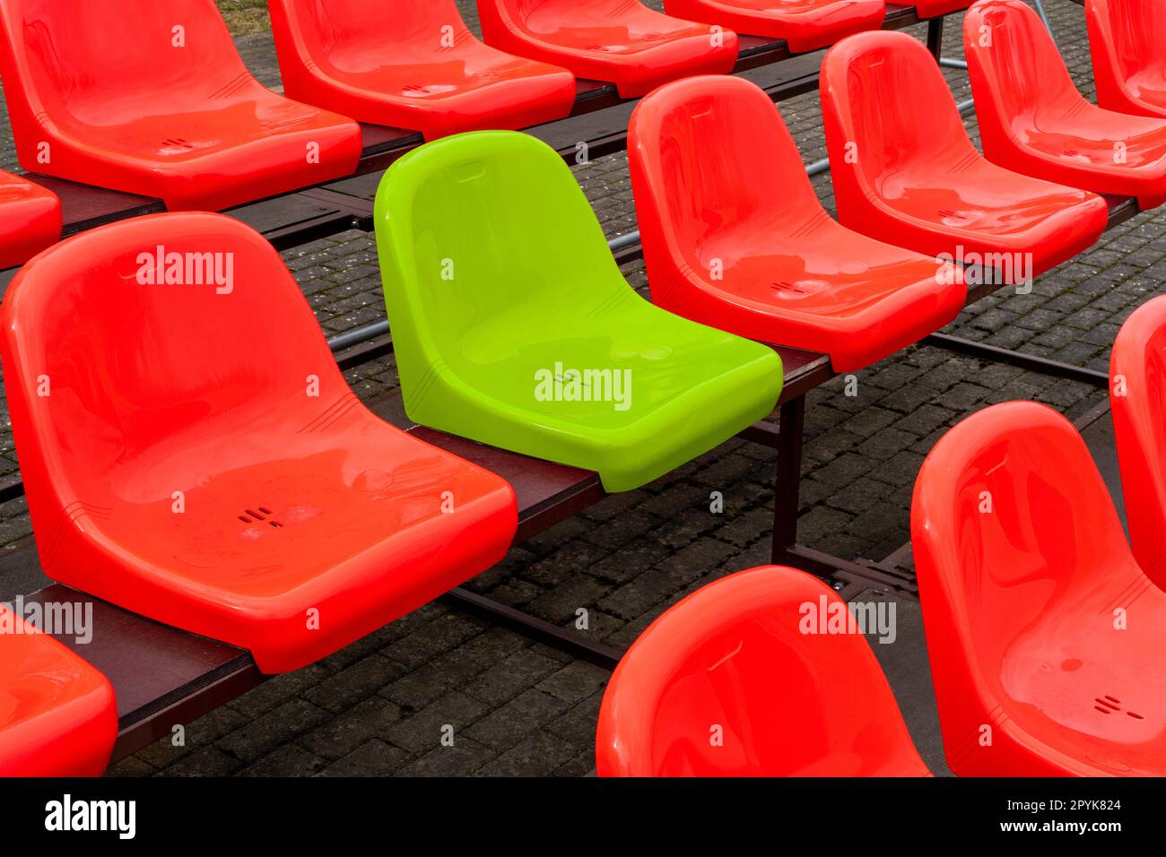 One green seat among red color seats in a stadium Stock Photo - Alamy