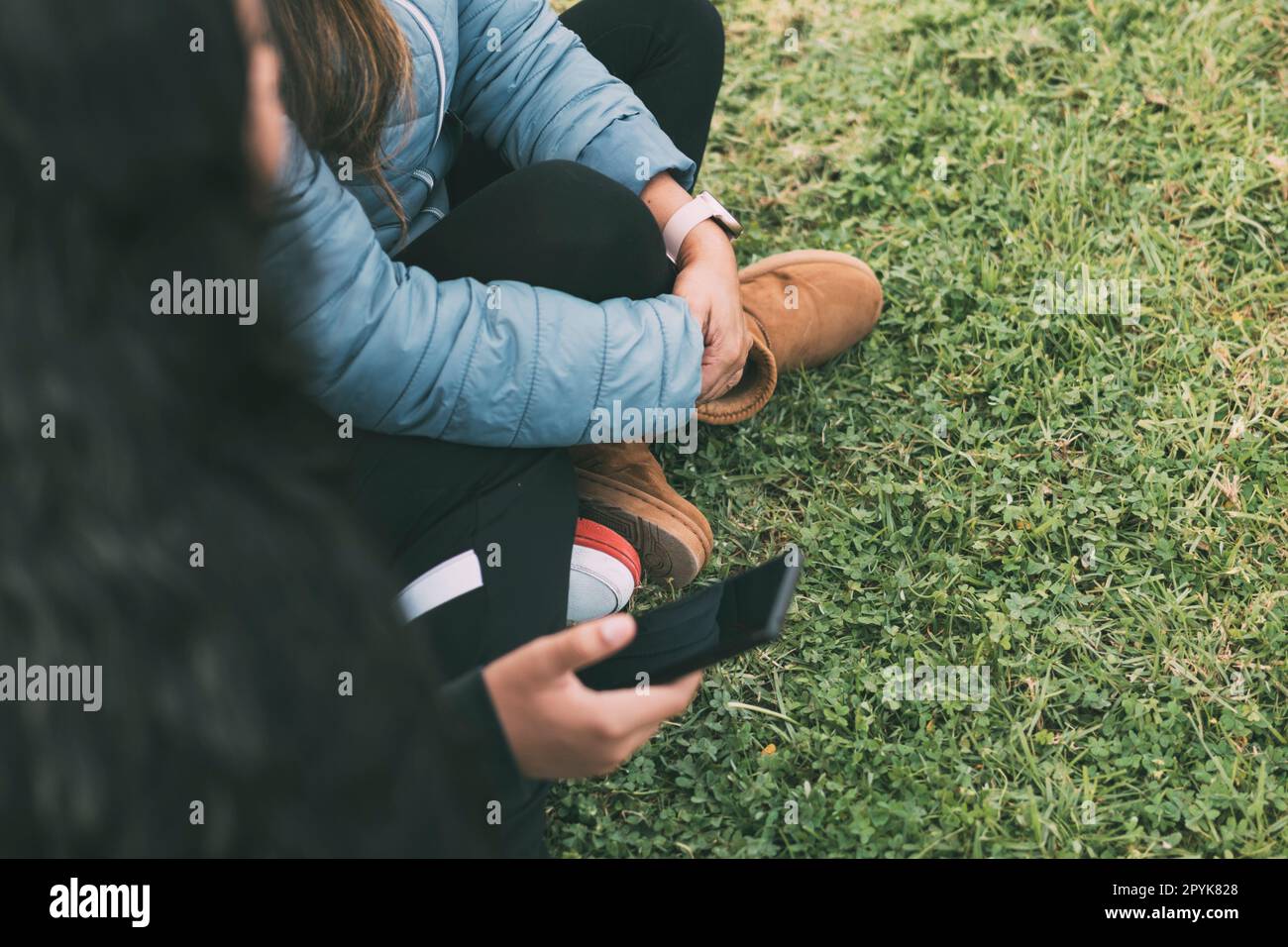 Hispanic friends bonding over technology in the park Stock Photo - Alamy