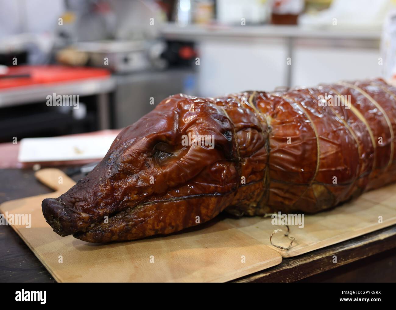 Baked suckling pig whole on a wooden board Stock Photo - Alamy