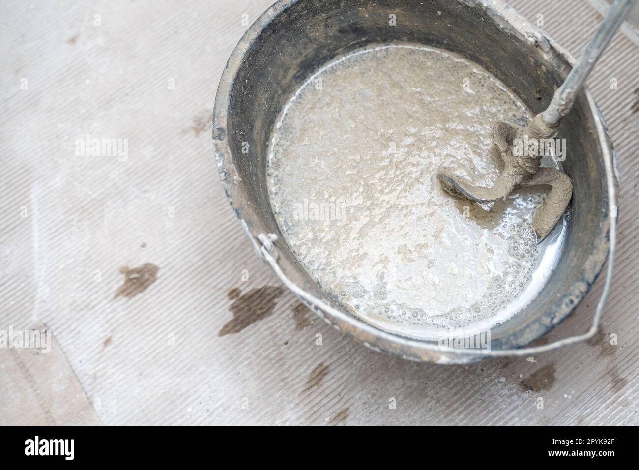 manual mixing of cement with the help of an electric mixer, cement in a ...