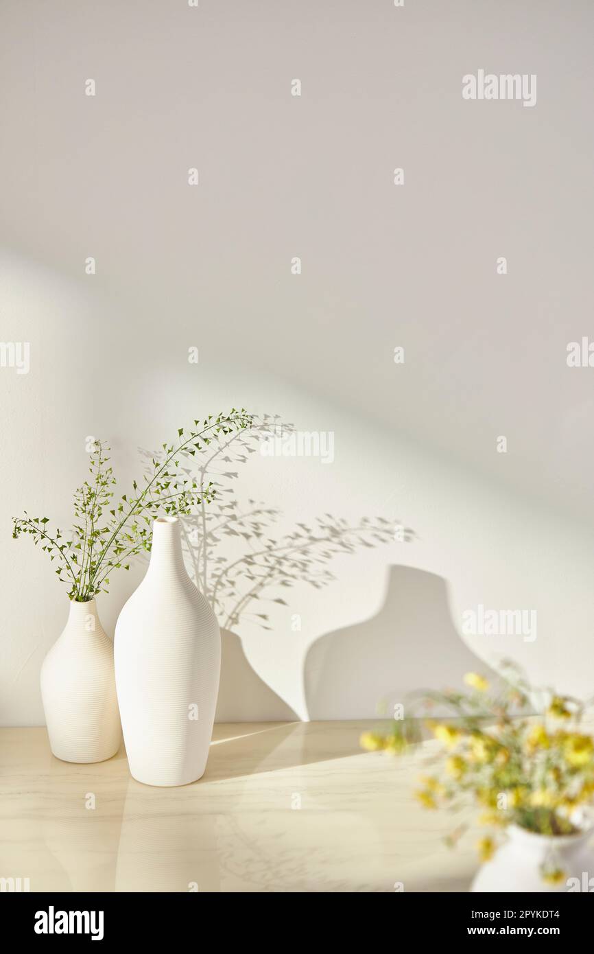Vases and objects on the table in a warm room with sunlight coming in ...