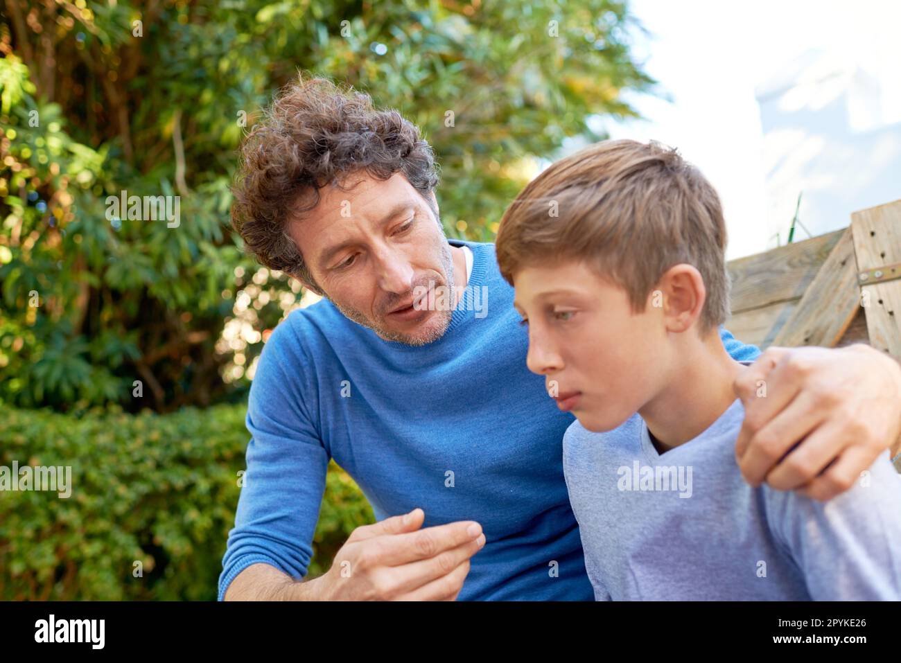 Family, father talking with son in backyard, bonding with love and care ...