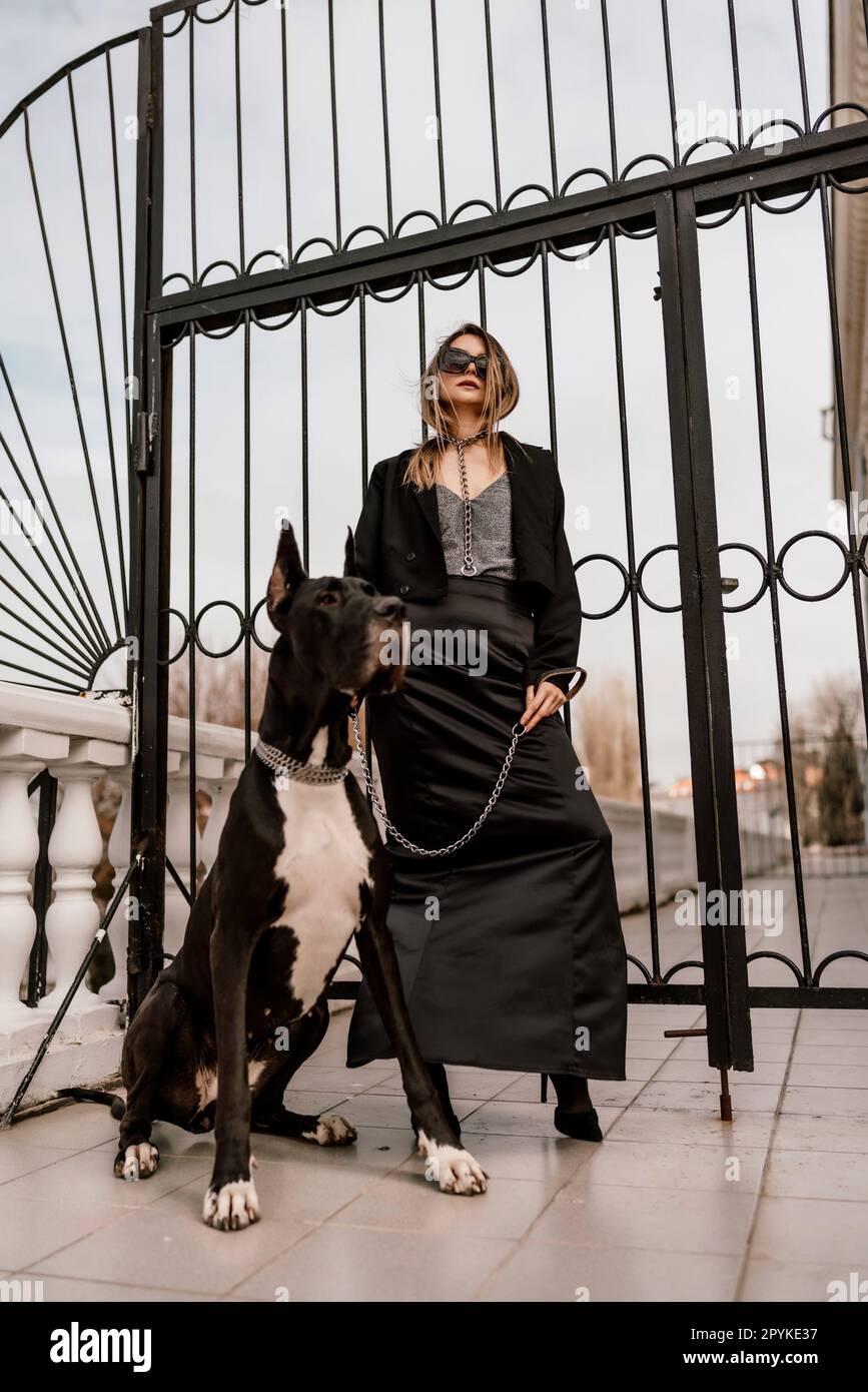 A woman walks with her Great Dane in an urban setting, enjoying the ...