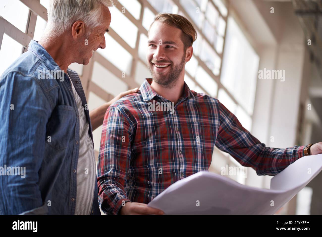 Building, employees and men with a blueprint, planning and discussion ...