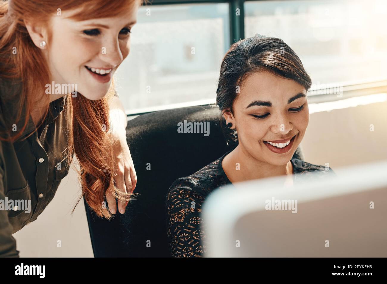 Nothing encourages productivity like teamwork. two young businesswomen ...
