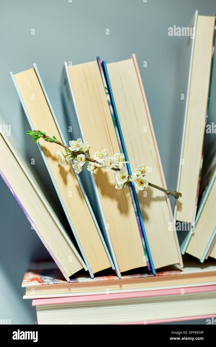 Stack of books with branch flowers, World book day, knowledge and ...