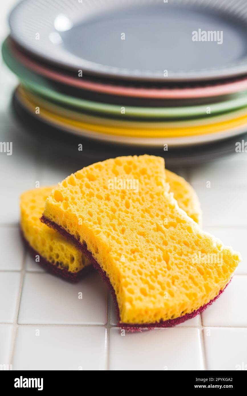 Sponge for washing dishes and plates on the tiles Stock Photo - Alamy
