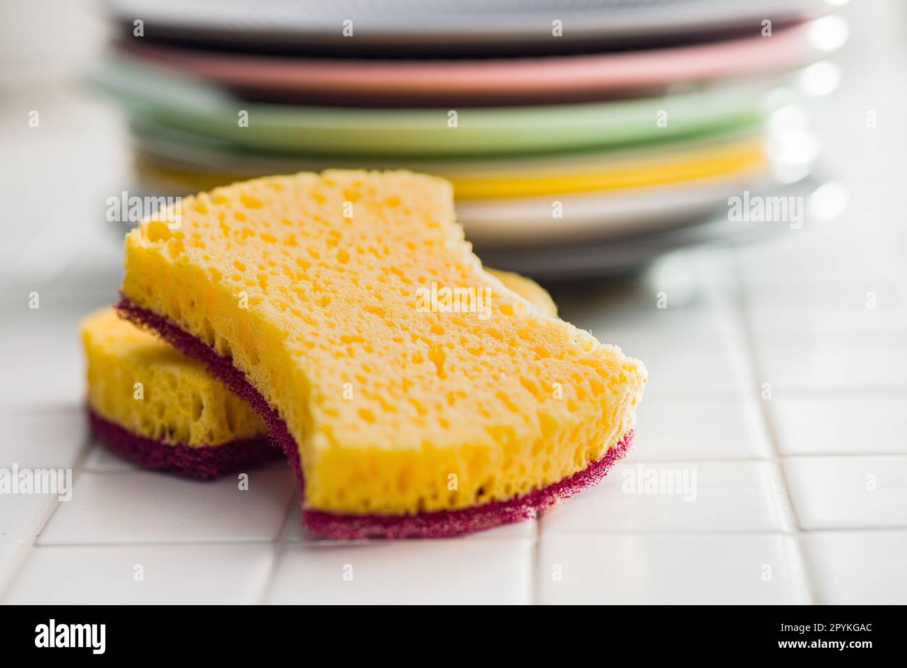 Sponge for washing dishes and plates on the tiles Stock Photo - Alamy