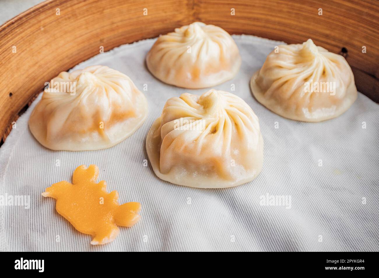 Xiao Long Bao dumplings, freshly steamed and served in a bamboo plate ...