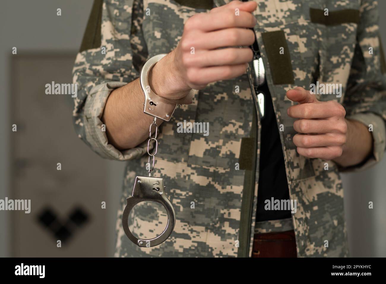 Handcuffed soldier in military army clothes. Close up of hands in ...