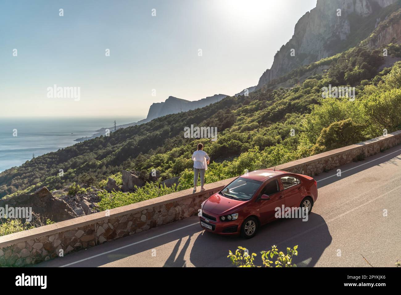 Mountain road woman. She walks along a parapet road in the middl Stock ...