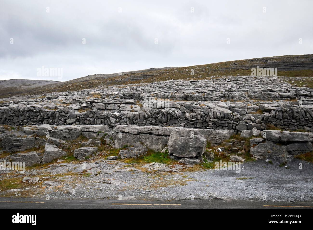 road carved into sloping limestone pavement with cross sections of the ...