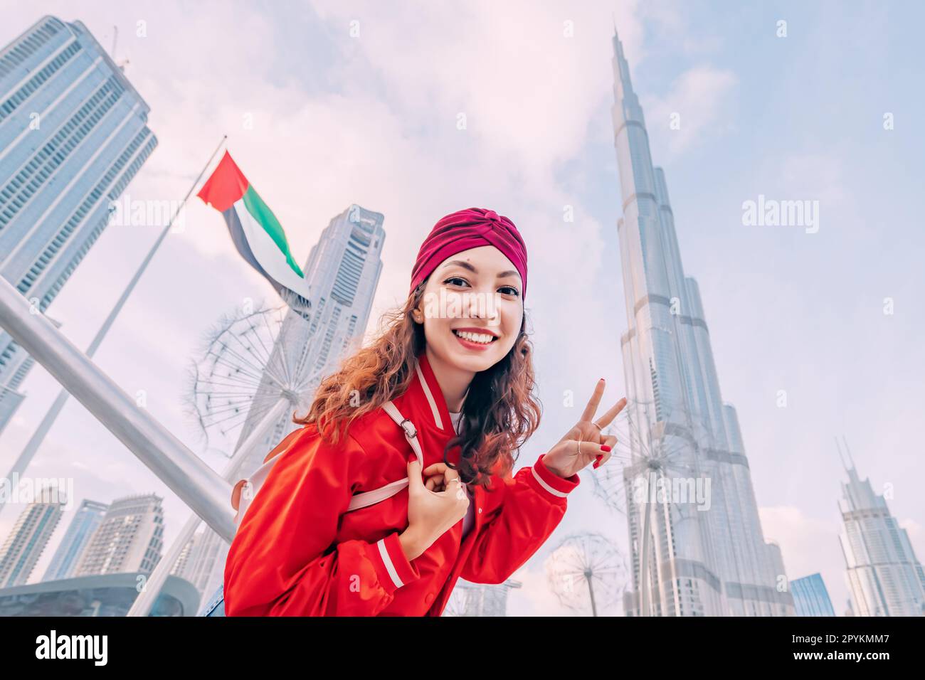 Happy asian girl tourist posing against Arab Emirates flag and iconic ...
