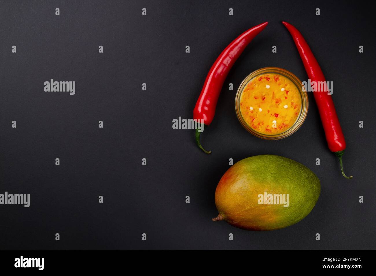 Mango, chili and mango chili sauce on dark grey background with free ...