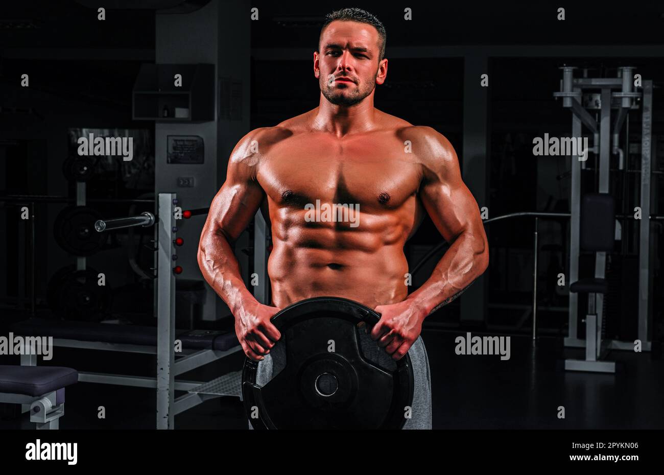 Powerlifter with heavy weight disk in sport gym. Bodybuilder training ...