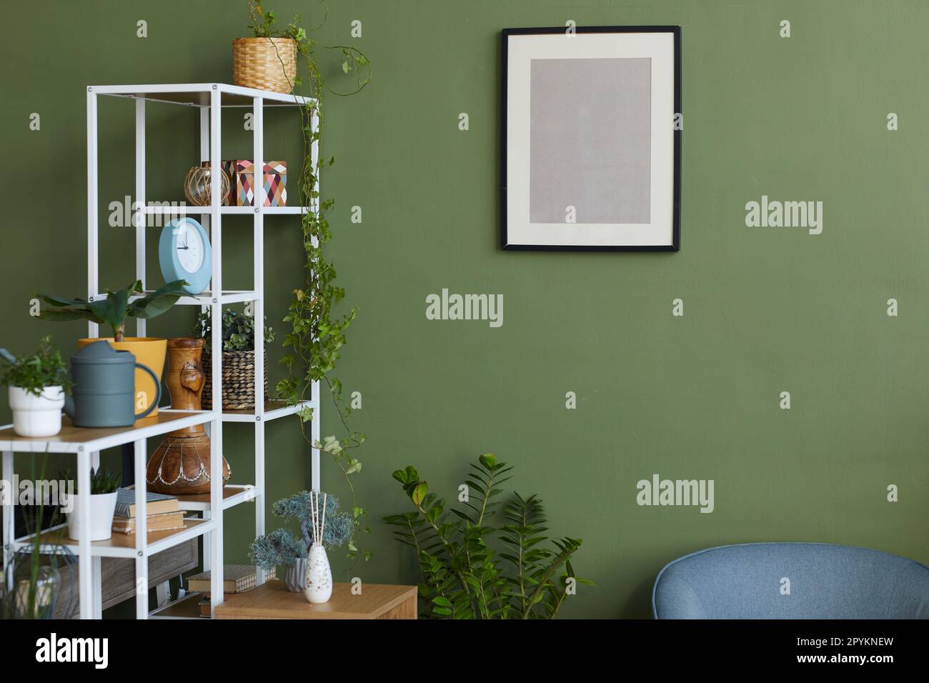 Domestic room with painting on green wall and modern shelves with ...
