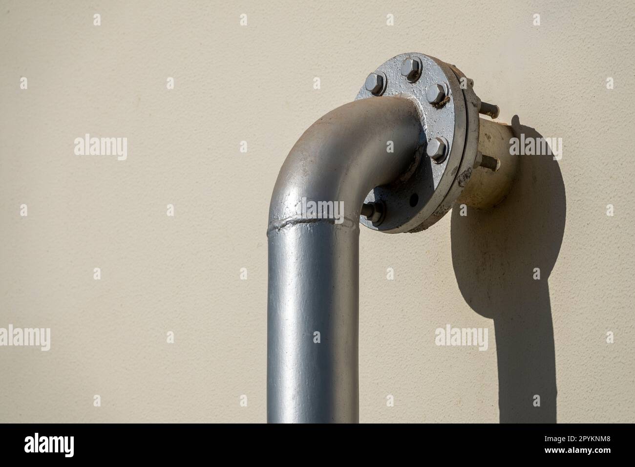 Silver galvanised pipe with right angled bend and a bolted plate ...