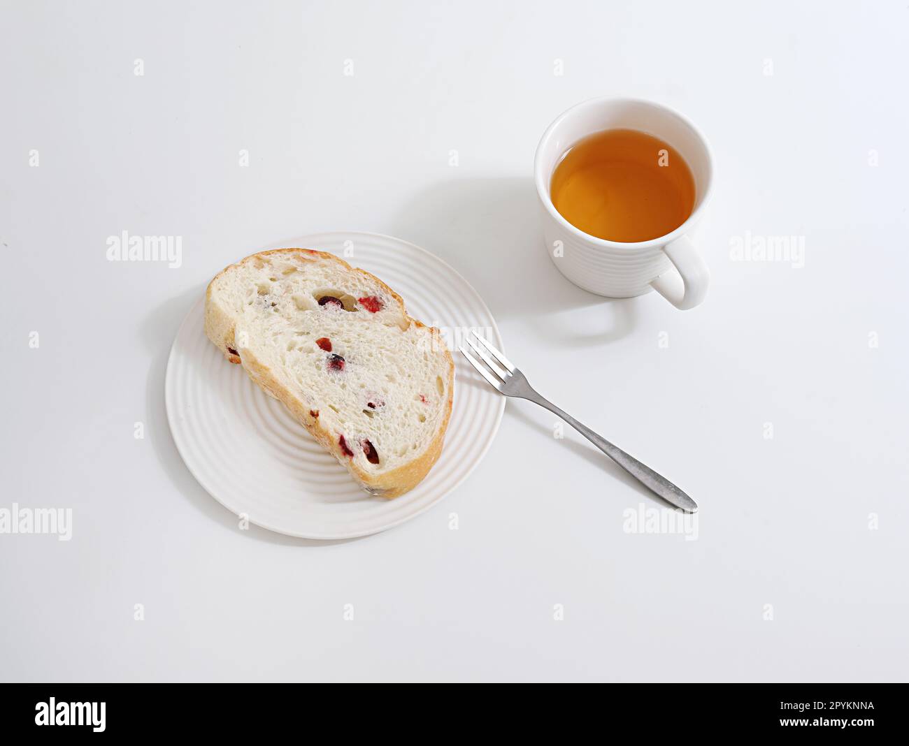 A slice of freshly baked bread and a cup of tea isolated on white ...