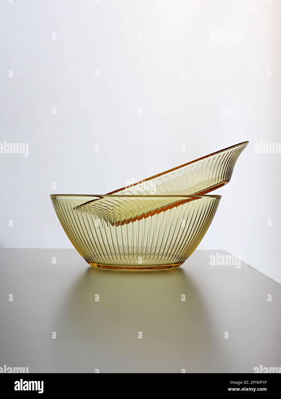 A glass bowl and plate on the table against a white background Stock ...