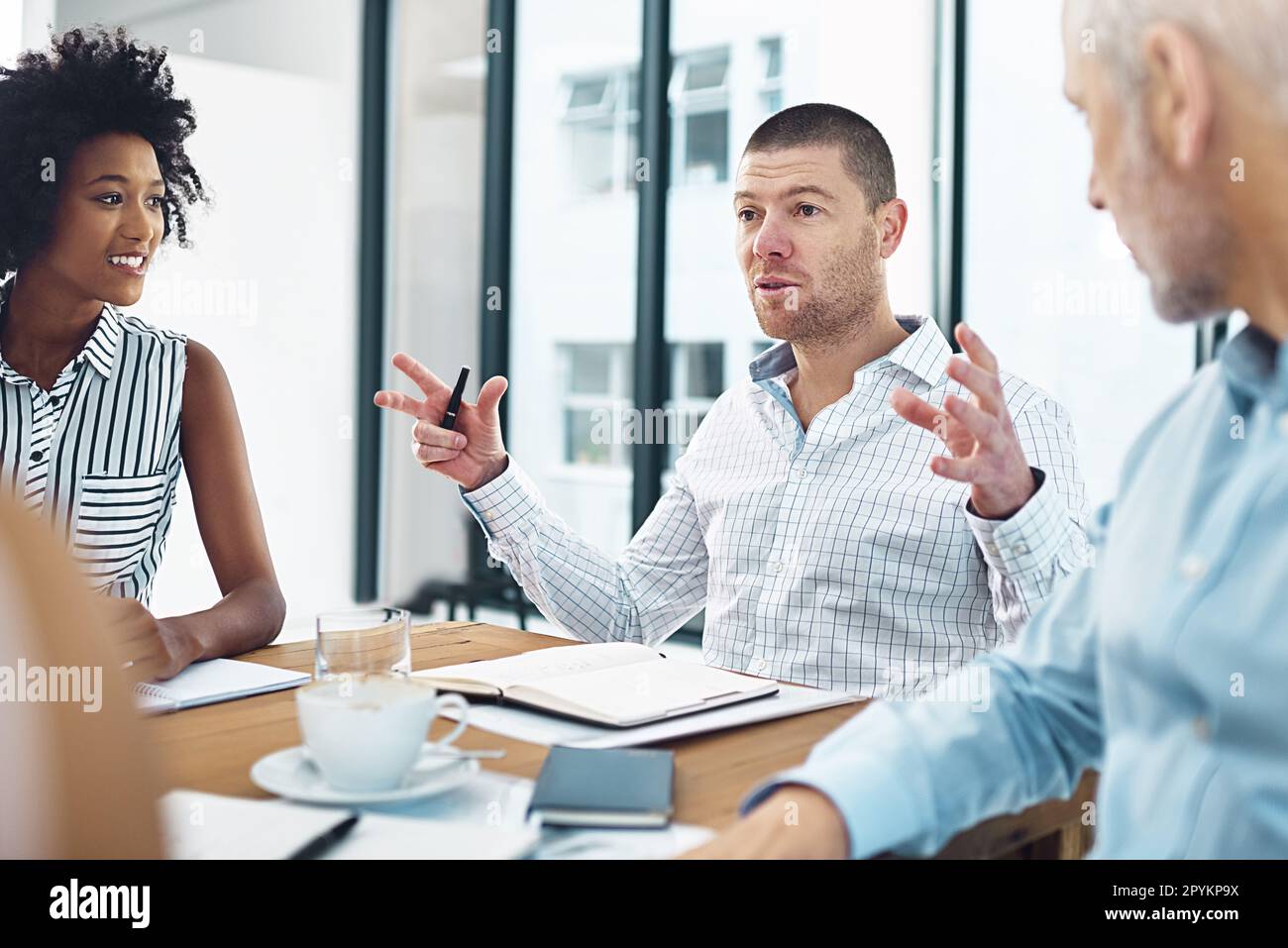 Explaining his vision in detail. a group of colleagues having a meeting ...