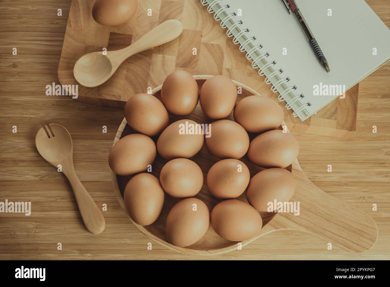 Eggs with wooden spoons and notebook Stock Photo - Alamy