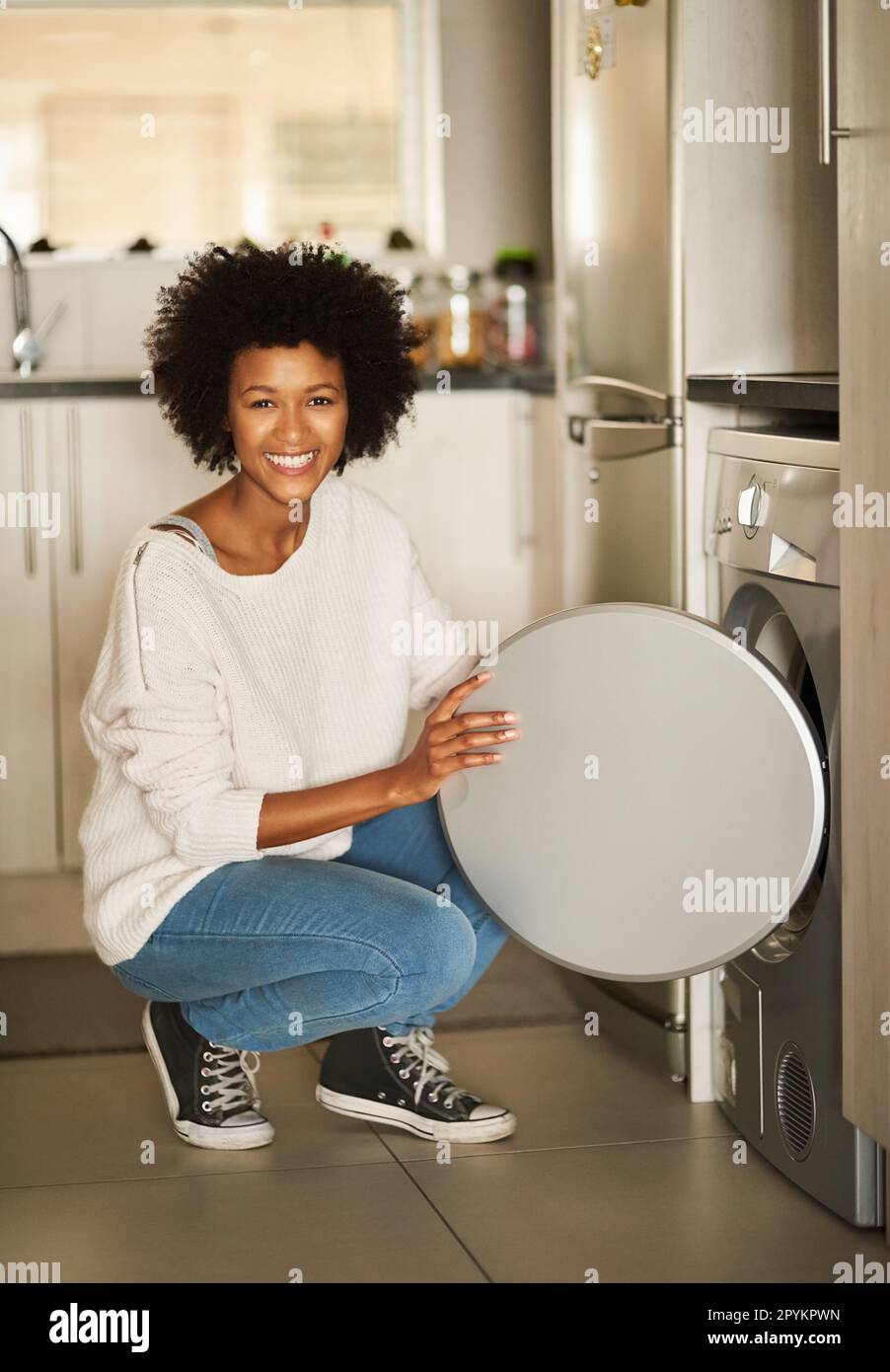 With a washing machine laundry day is a breeze. a young woman doing ...