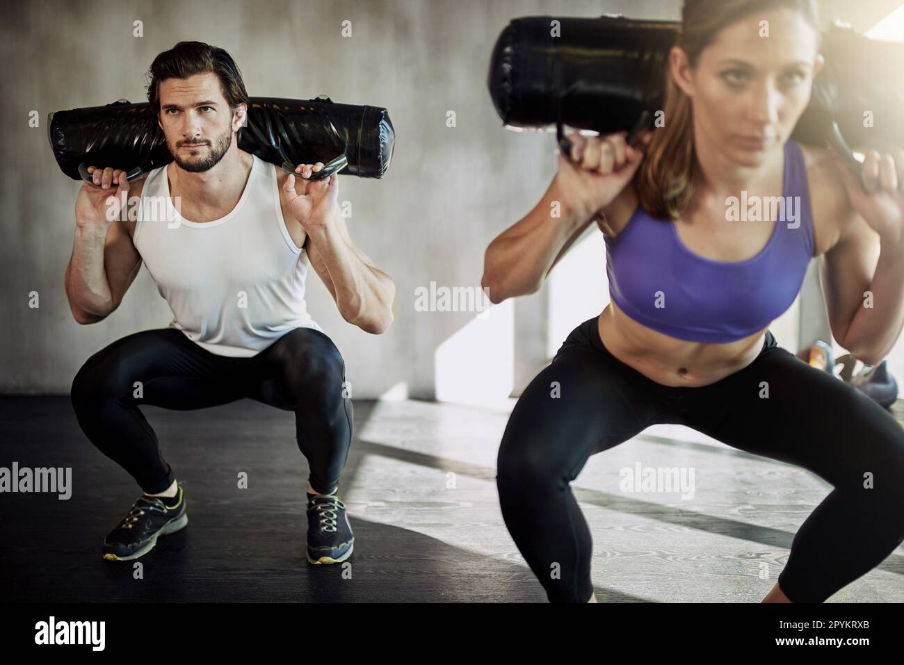 Every workout counts. two young people working out in the gym using ...