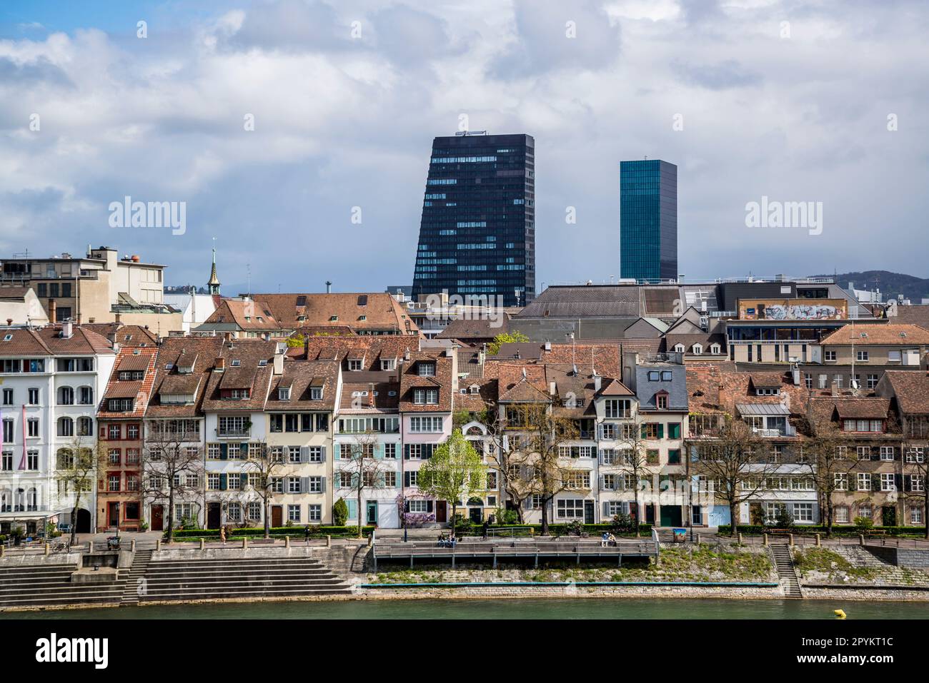 Modern tower blocks looming beyond the old houses along the river Rhine ...