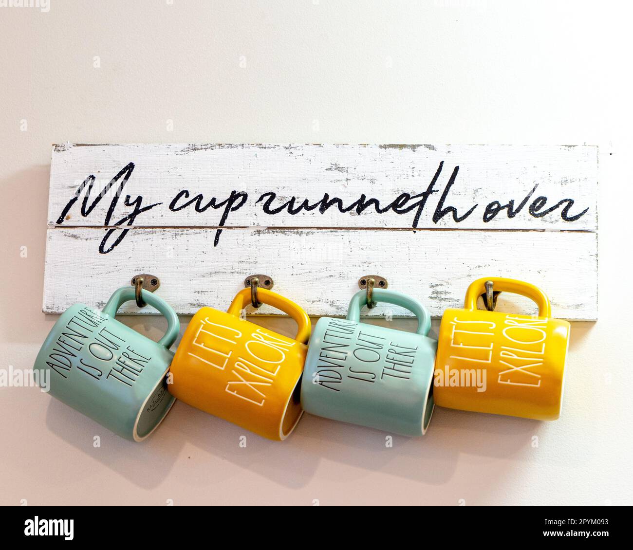 Decorative display of coffee mugs with quote, "My cup runneth over ...