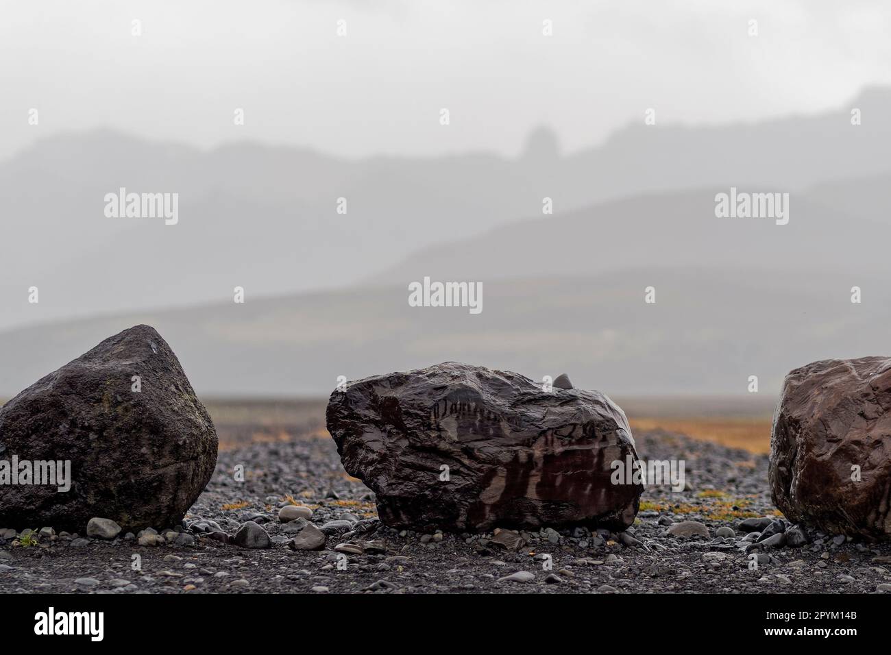 Three large rocks stop vehicles from traveling along a rocky dirt road ...