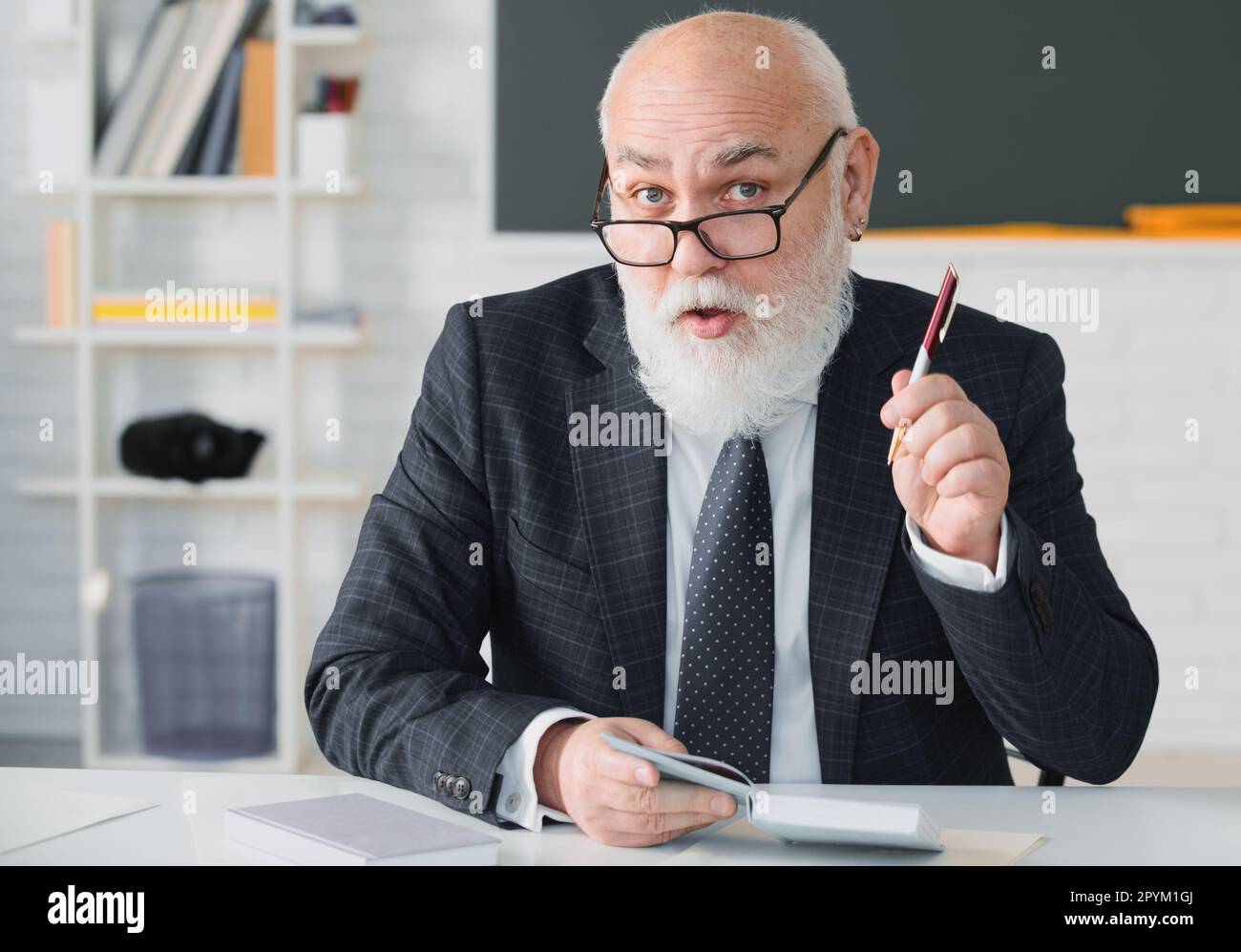 Teacher preparing for university exams. Professor holding a book and ...