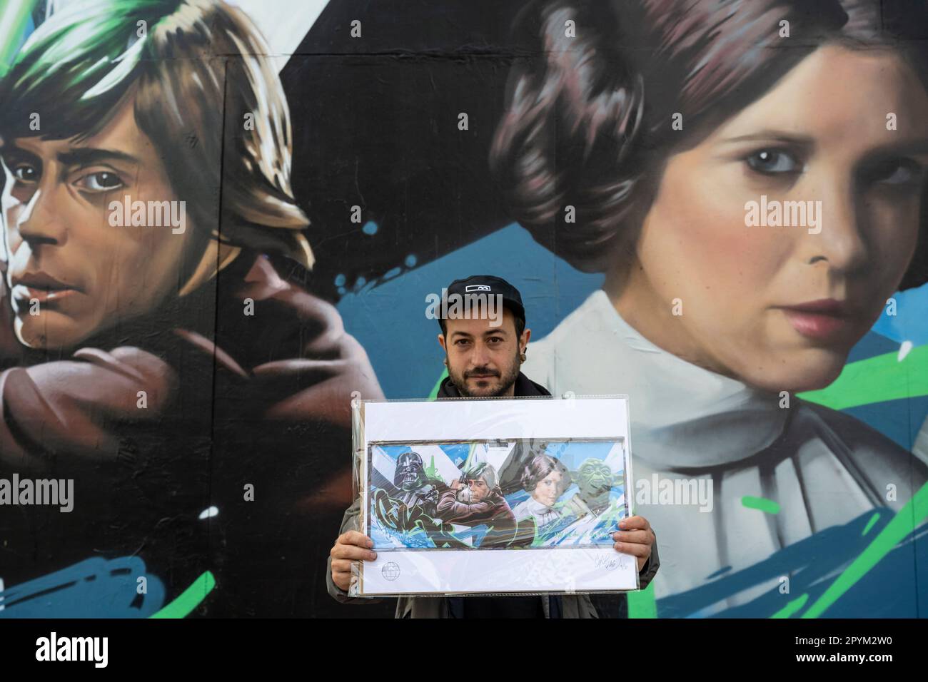 London, UK. 4 May 2023. Street artist Nacho Welles with a print of his ...