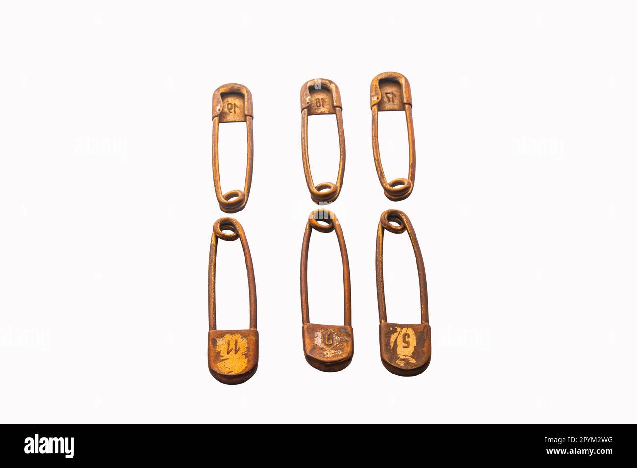 An old and rusty safety pin set isolated on white background Stock ...