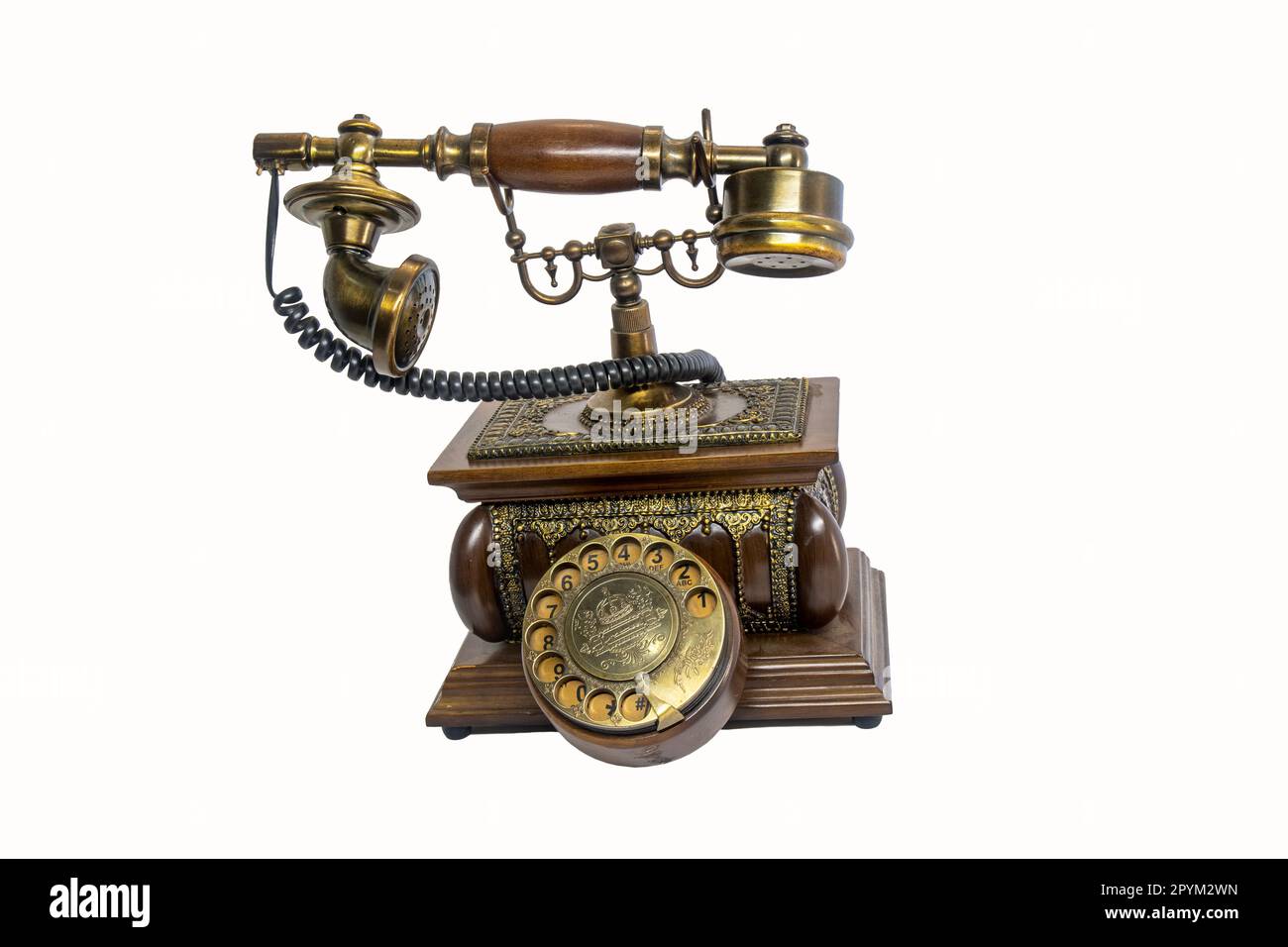 A vintage telephone of brown and golden color on a white background ...