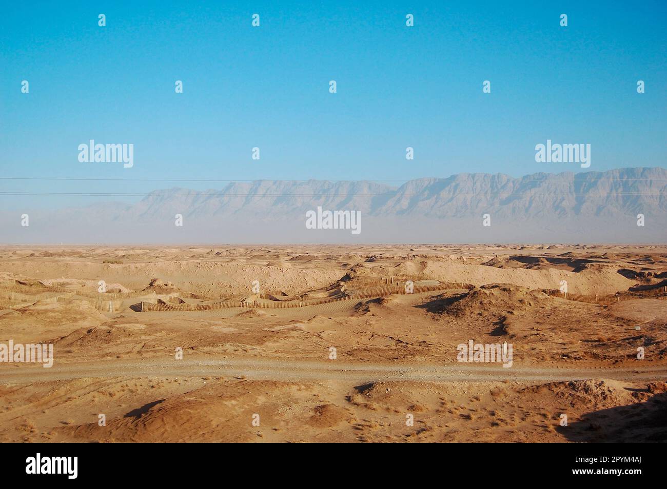A scenic landscape of a desert terrain with towering mountain in the ...