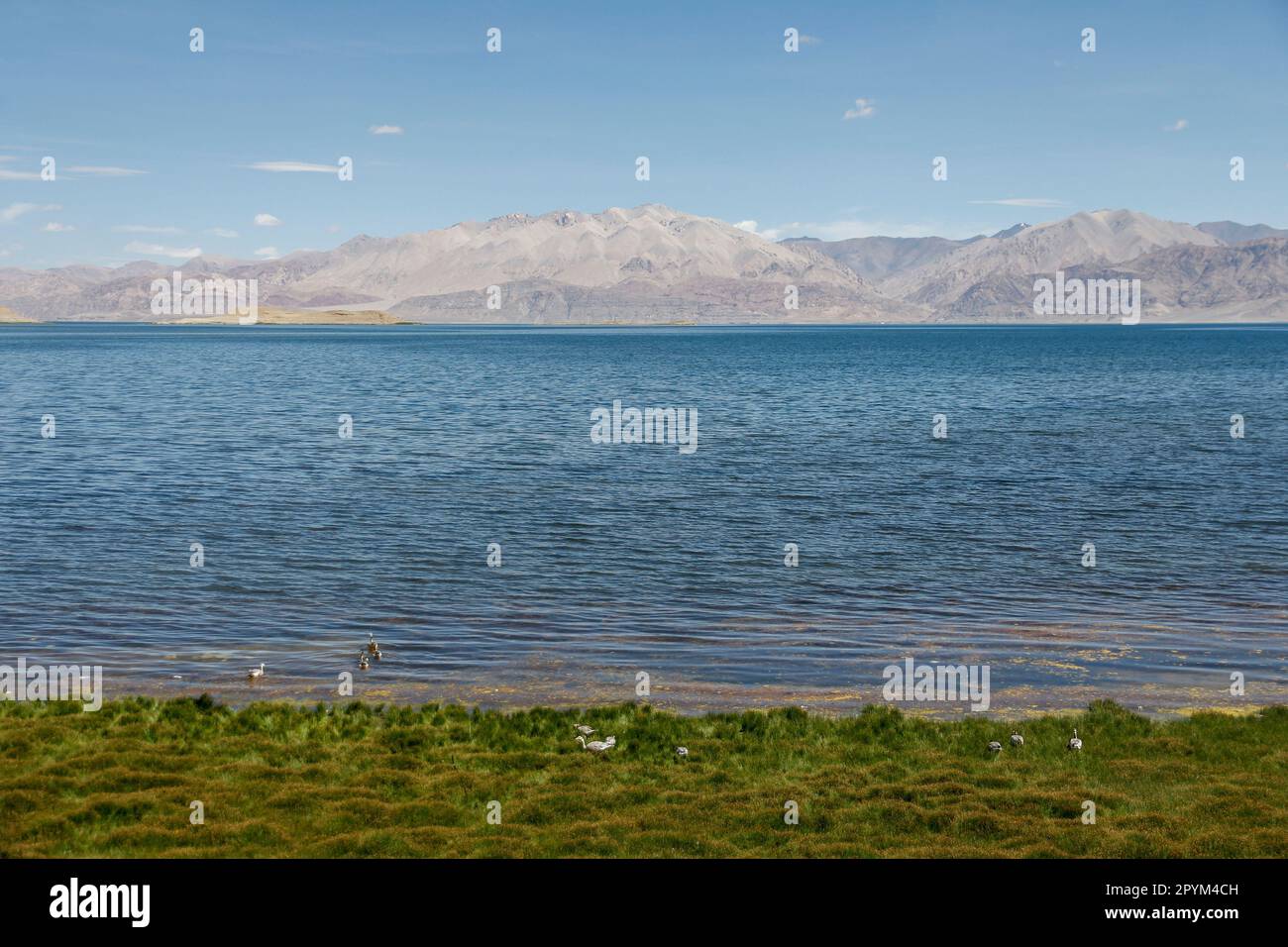 A scenic view of a crystal blue lake surrounded by towering mountains ...
