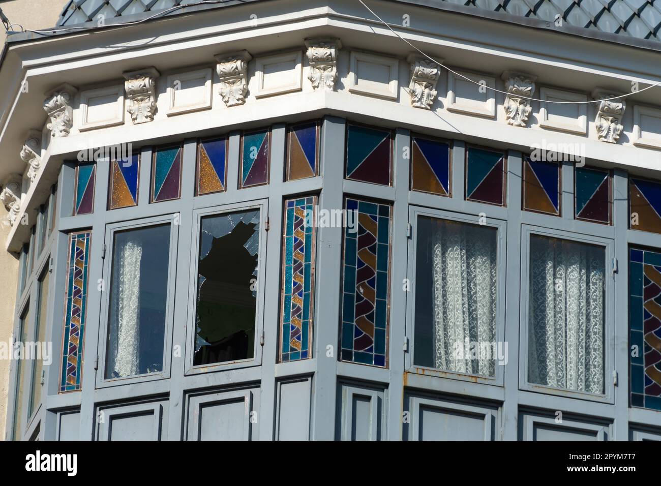 Close-up of a broken window on the beautiful facade of a balcony with ...