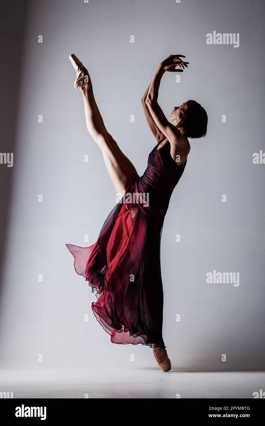 Half silhouette ballerina with a waving red dress. Elegant female ...