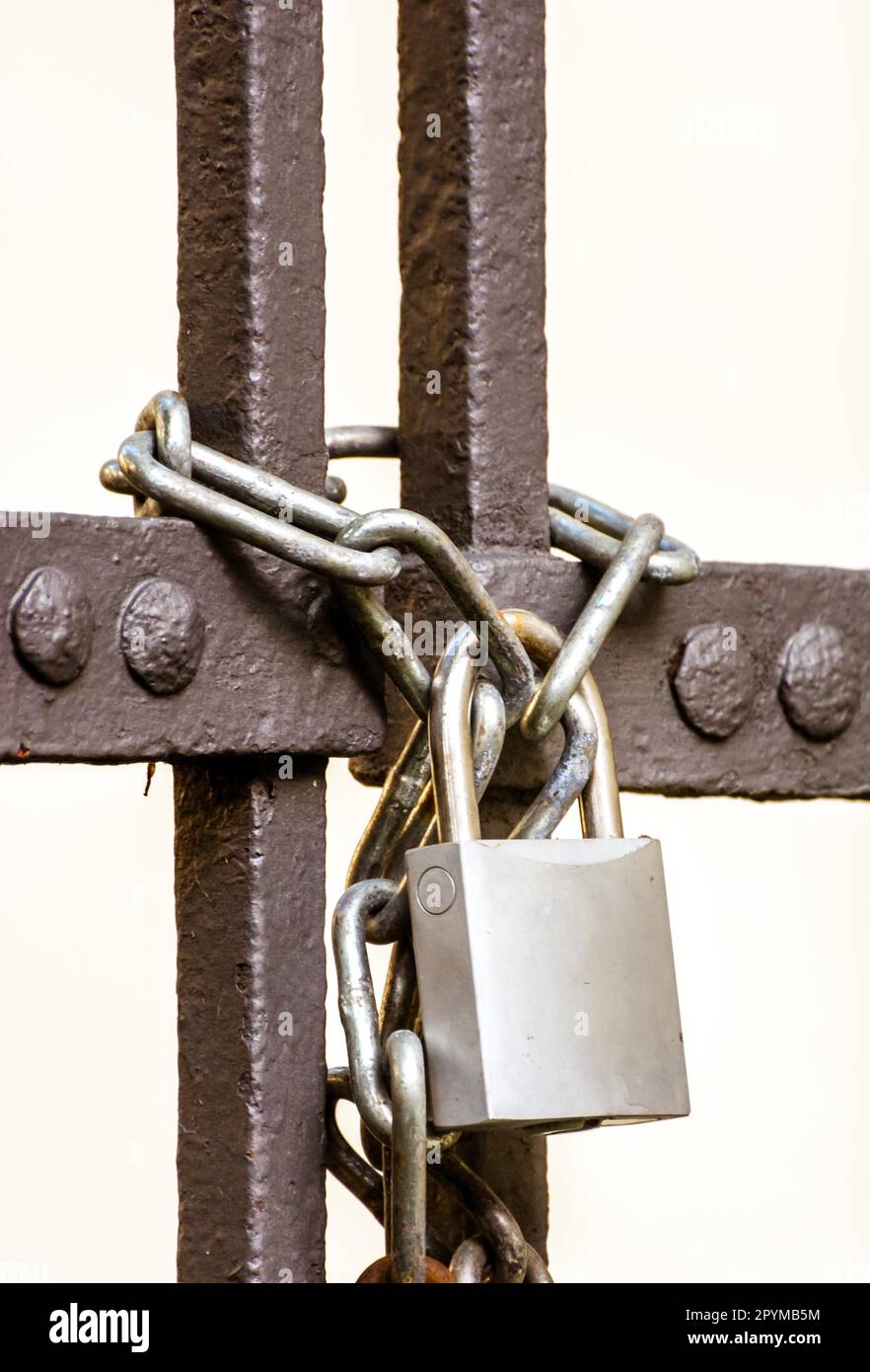 Iron gate scured with a chain and a padlock Stock Photo - Alamy