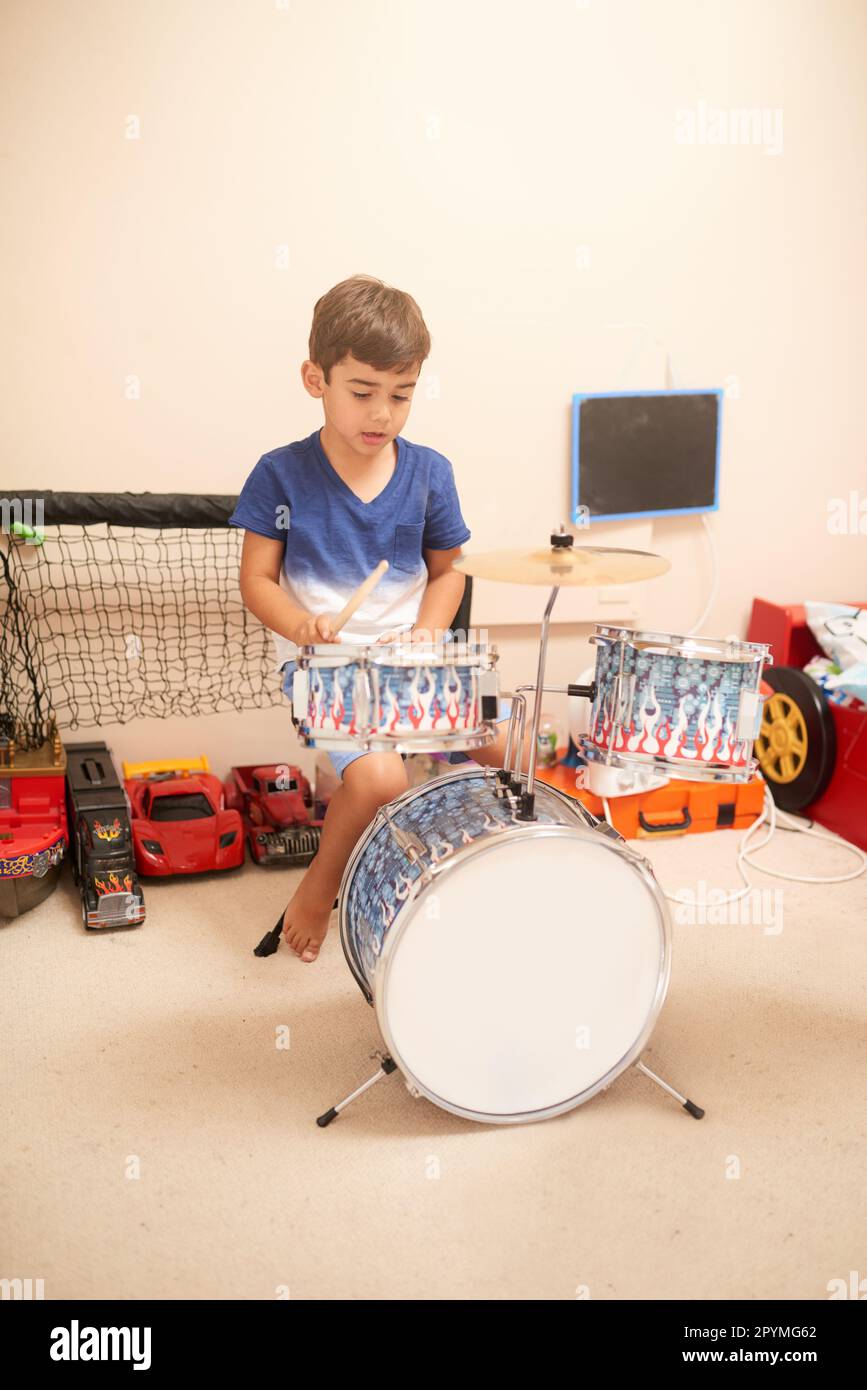 Channeling his inner drummer. a little boy playing with a drum set at ...