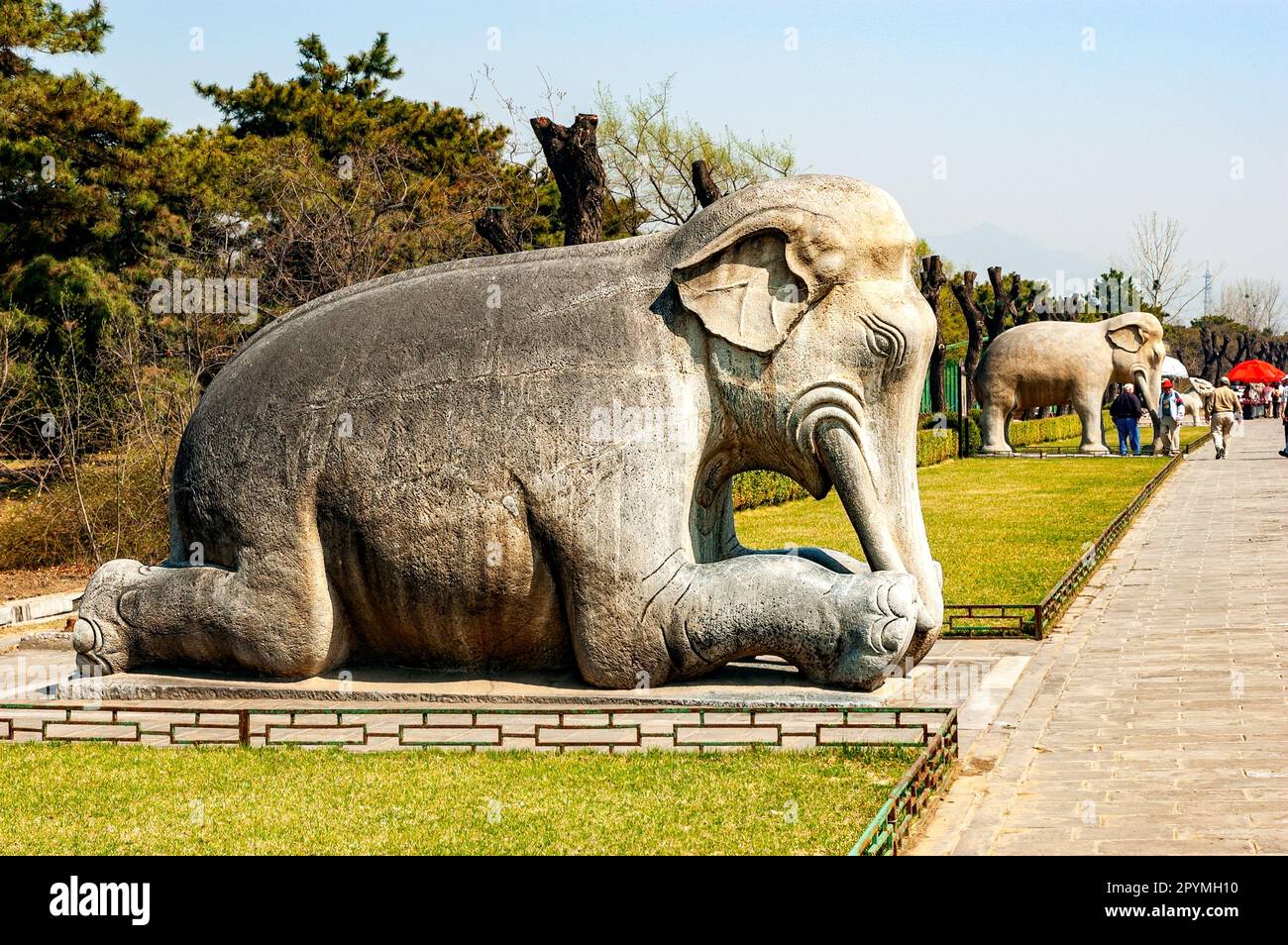 Ancient white stone statues of kneeling and standing Elephants along ...