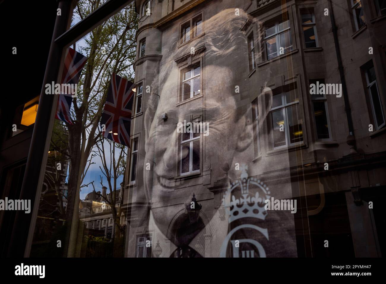 A shop window decorated with a photo of King Charles III is ...